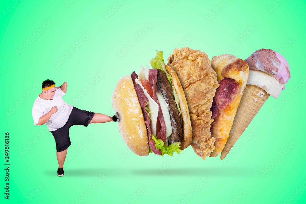 Angry fat man kicking fast foods Stock Photo | Adobe Stock