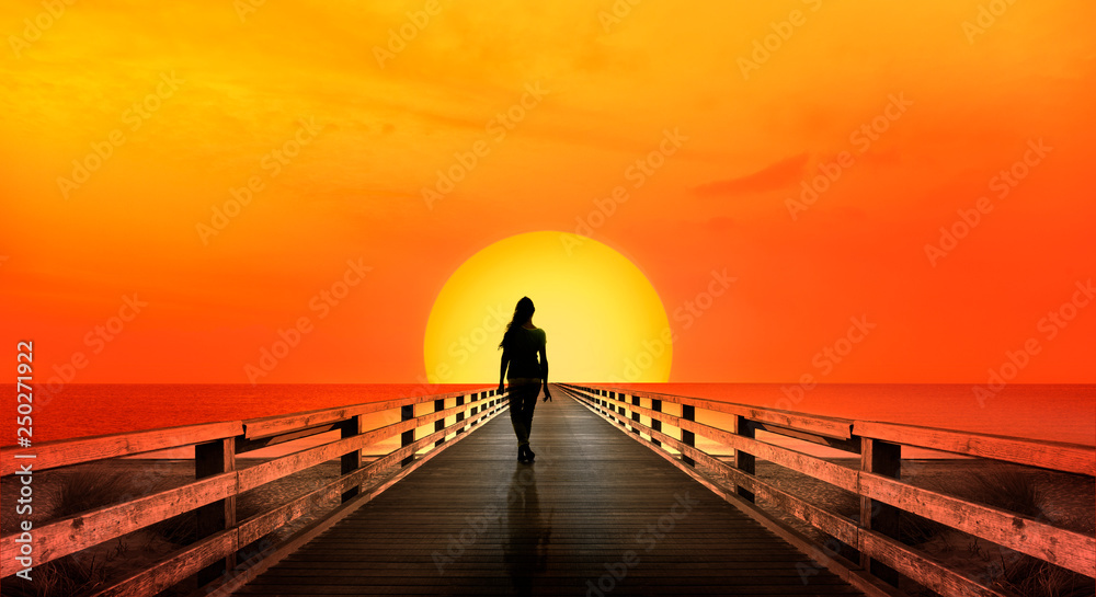 Woman walking into sunset Stock Photo | Adobe Stock