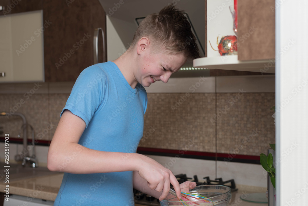 Cute emotions teenage boy cooking at home. Stock Photo | Adobe Stock