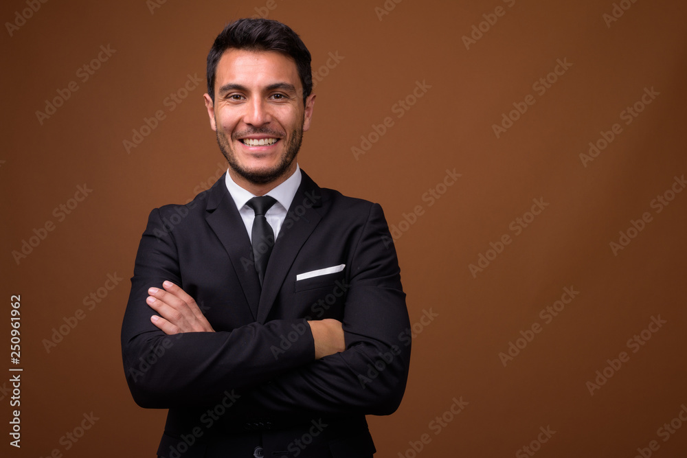Young handsome Hispanic businessman against brown background Stock ...