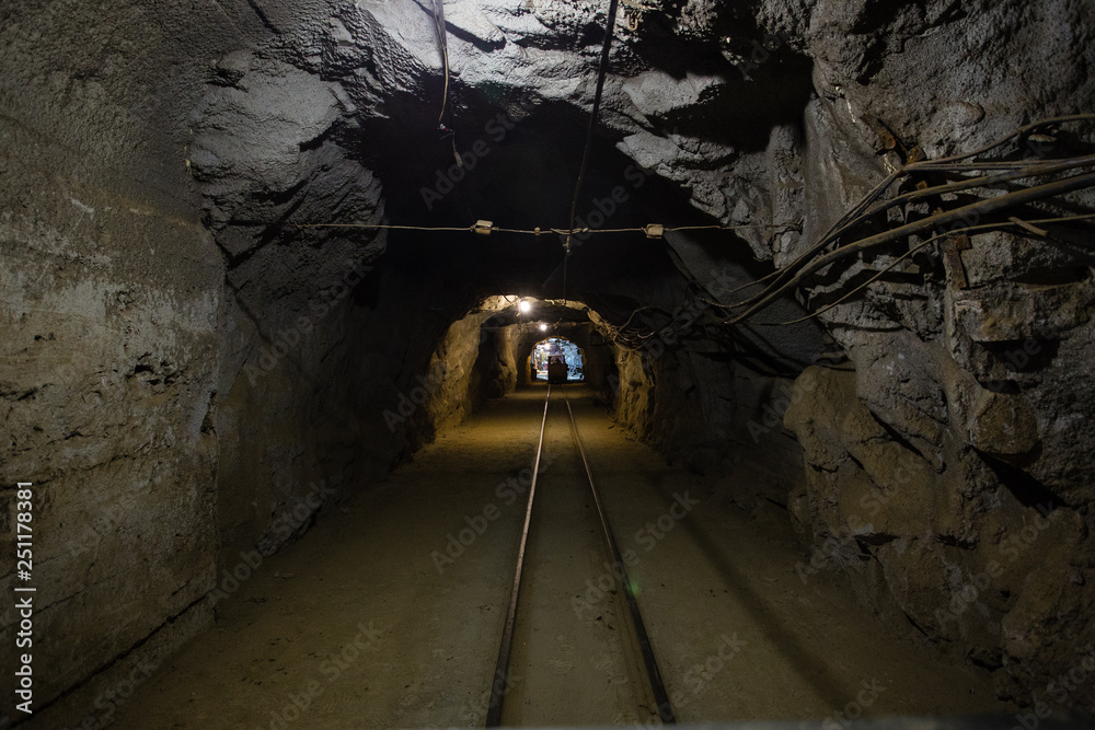 Underground gold ore mine shaft tunnel gallery passage with rails and ...