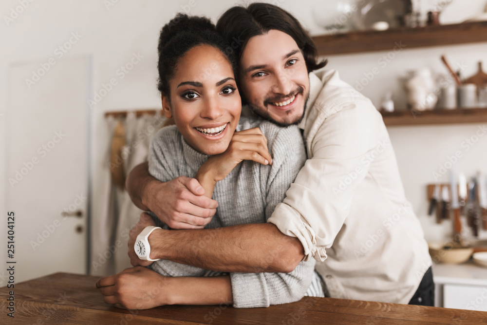 Smiling man dreamily embracing beautiful african american woman ...