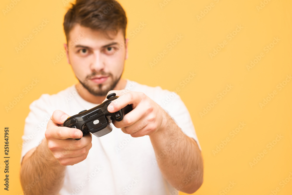 Close-up photo of a bearded man holds the gamepad and plays video games ...