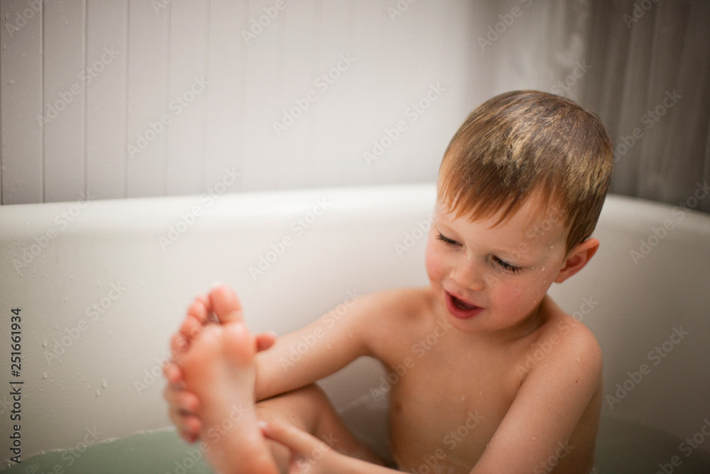 Young blond boy washing his feet in the bath Stock Photo | Adobe Stock