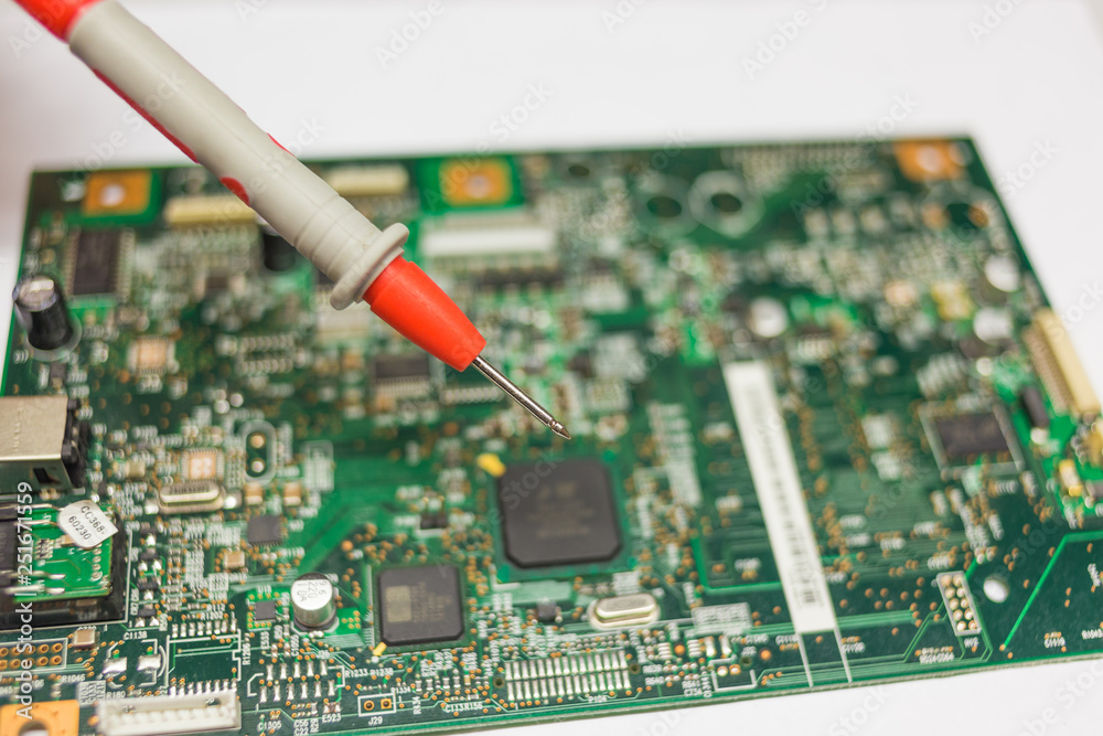 electrical board with soldered integrated circuits and probe needle ...