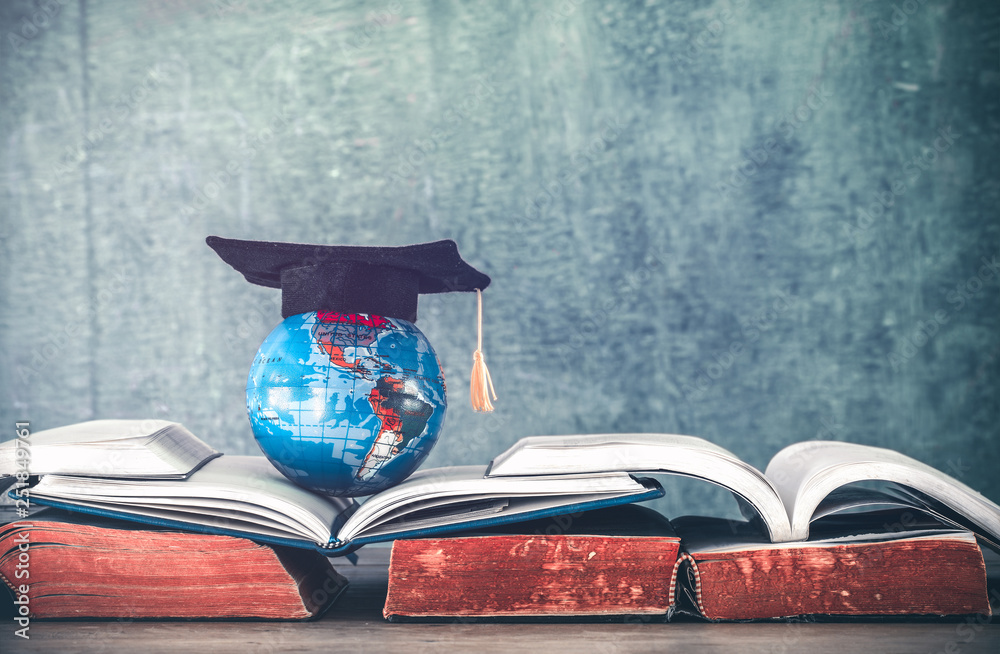 Foto de Stock Graduation cap with Earth globe model map on book stack ...