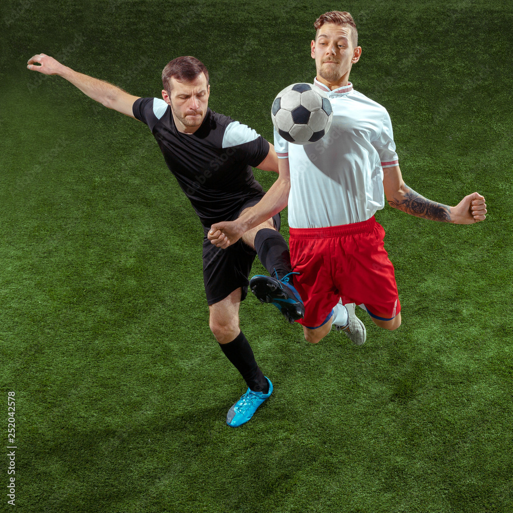 Football player tackling for ball over green grass background ...