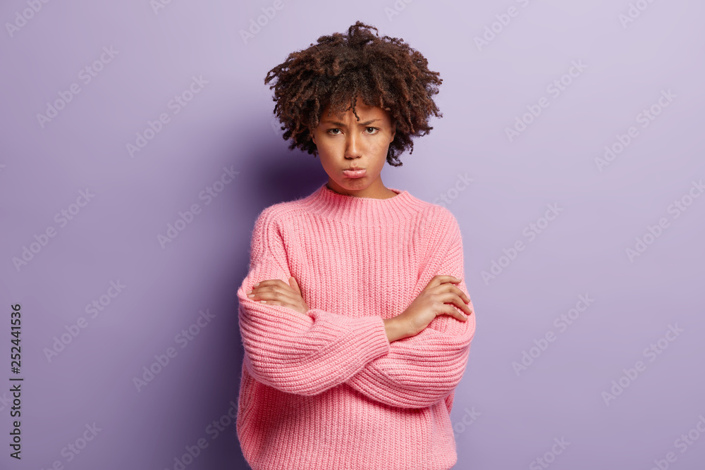 Upset dark skinned young lady has dejected facial expression, crosses ...