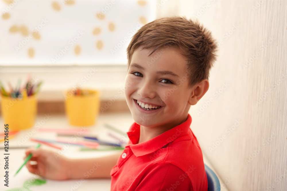 cute happy brunette child 9-10 years old in red shirt drawing a drawing ...