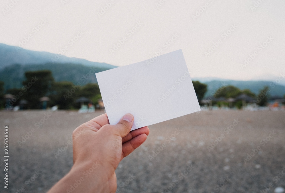 Empty paper note in hand at amazing landscape background. Travel and ...