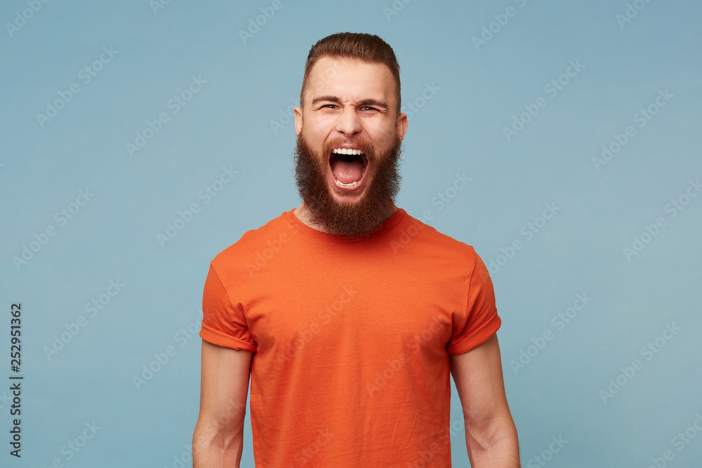Photo Stock Man standing shouts loudly, facial expression of anger ...