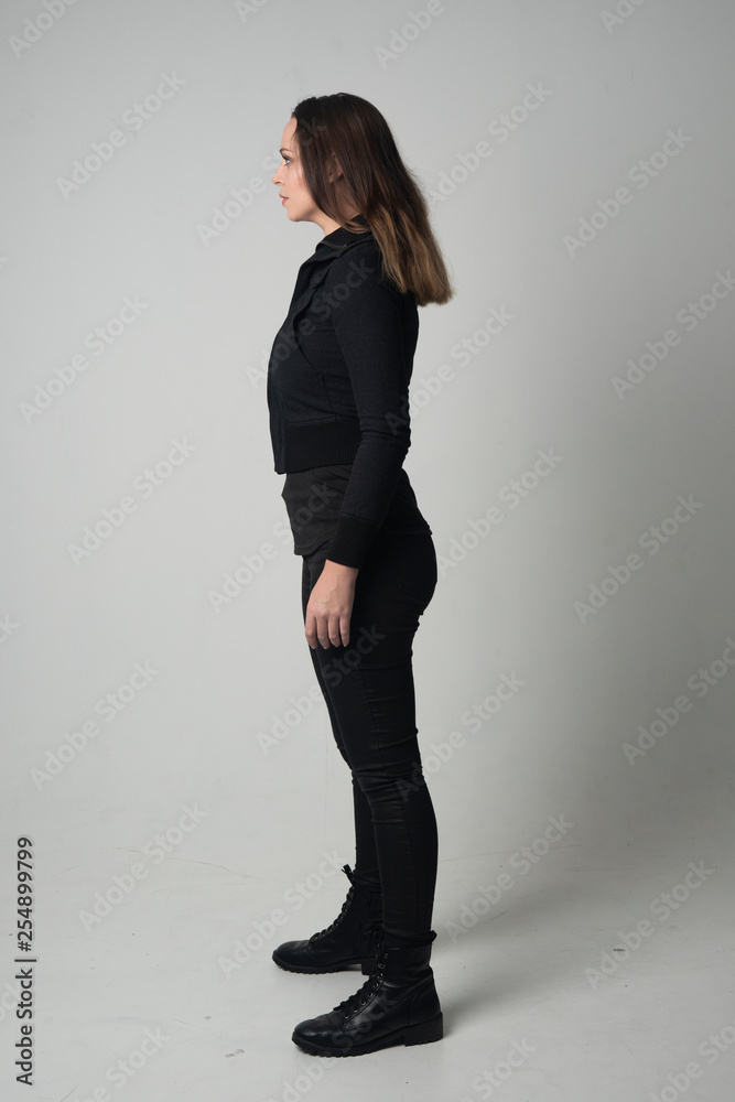 full length portrait of a brunette girl wearing modern black jacket and ...