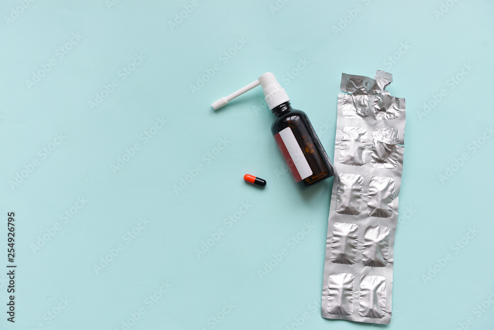 capsule pills in a blister pack, spray on a blue isolated background ...