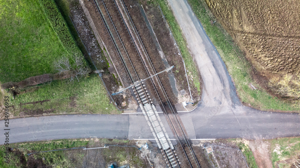 vue aérienne d'un croisement entre une route et des rails Stock Photo | Adobe Stock