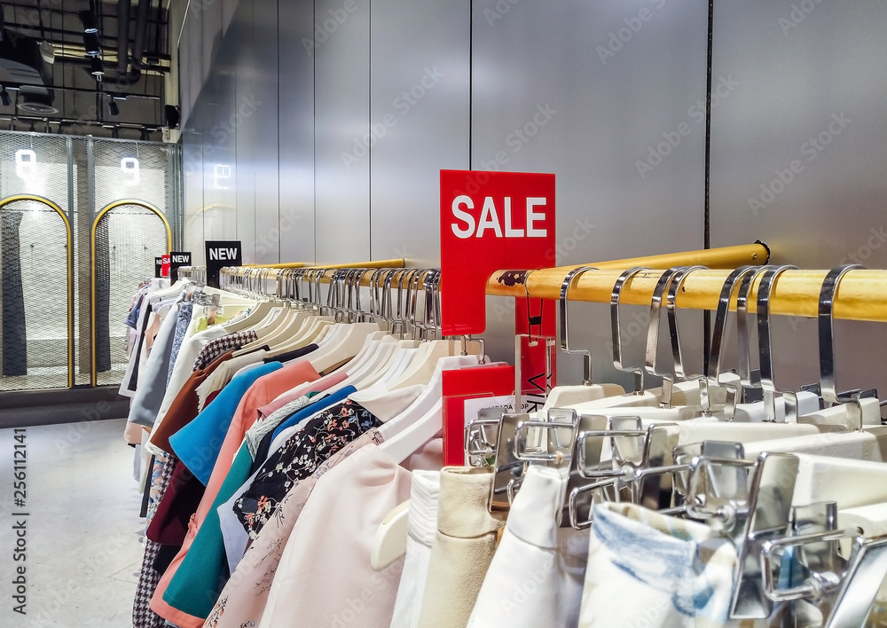 Red sale sign on clothing rack in modern shopping mall or department ...