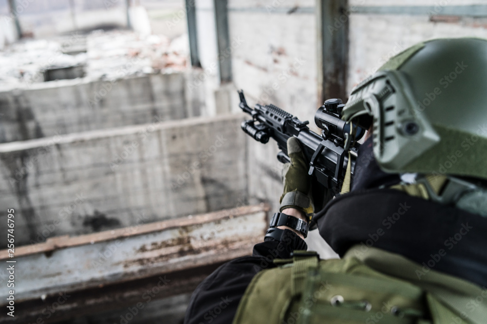 Foto Young Special forces SWAT soldier aiming with assault rifle gun at ...