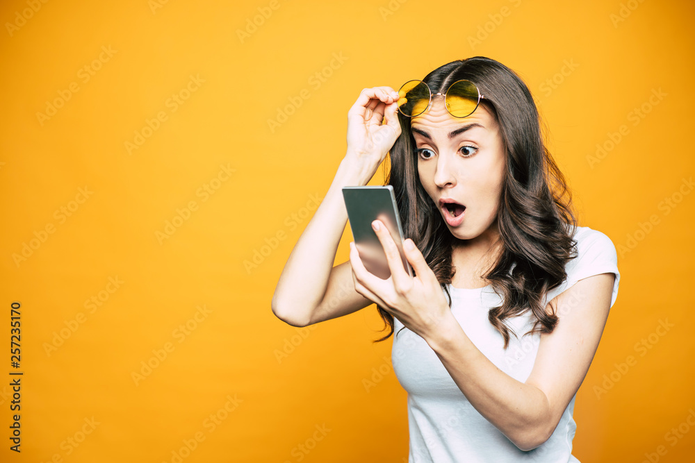 Oh, my! Gorgeous girl with a phone in her hand is surprised by ...