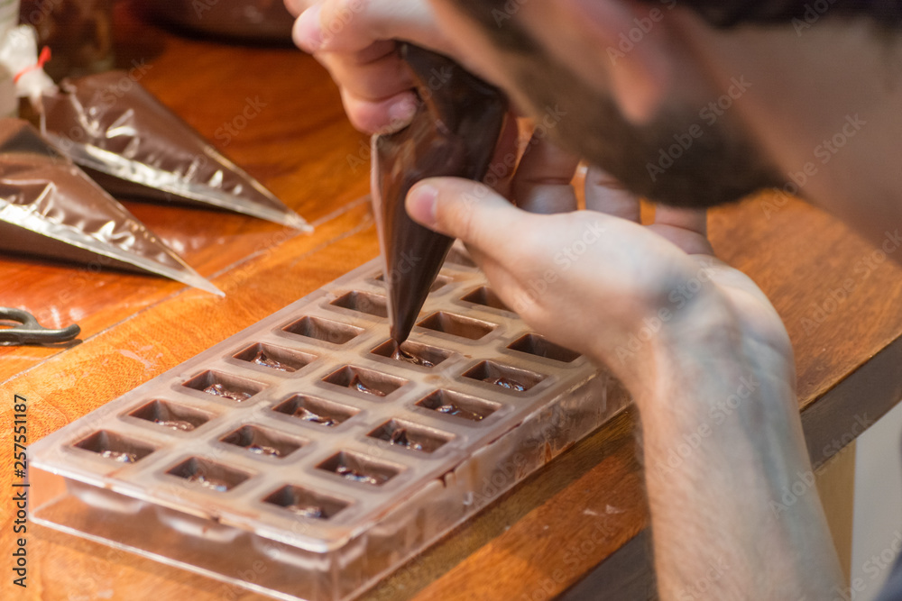 Part of the process of making homemade artisan chocolate sweets with ...