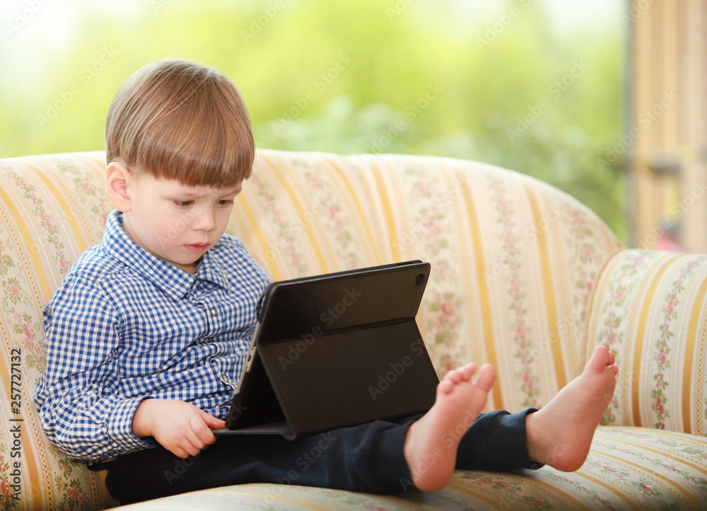 Ein kleiner Junge bedient ein ipad Stock Photo | Adobe Stock