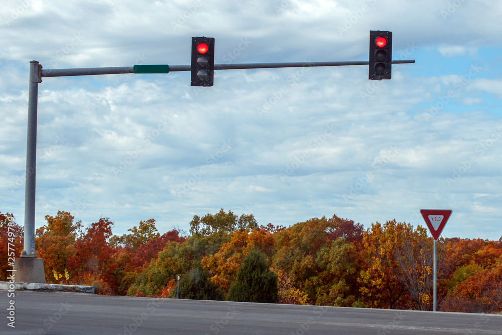 Red traffic lights against a blue sky on a fall day in Missouri makes a ...