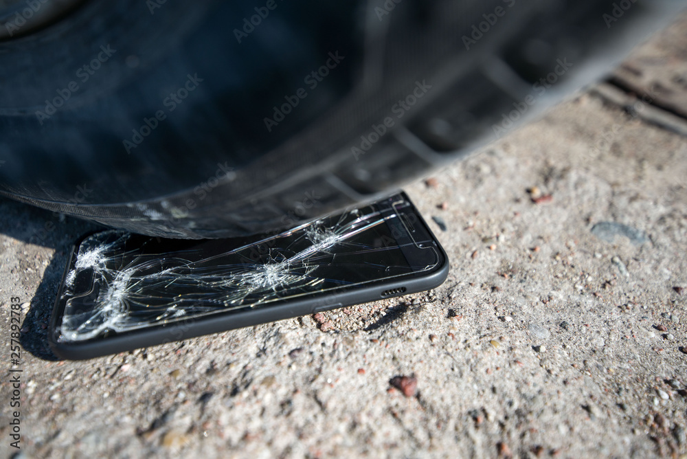 Foto de Stock Broken and damaged smartphone with cracks on glass screen ...