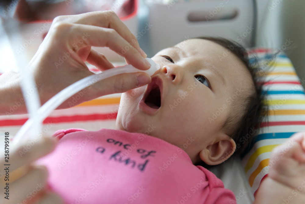 Asian young baby has been sucking snot from running nose symptom by her ...