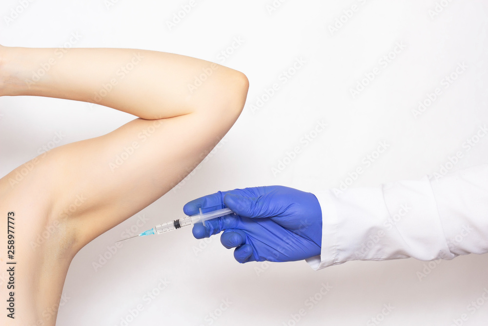 Doctor makes an injection in the armpit of a girl against sweating and ...