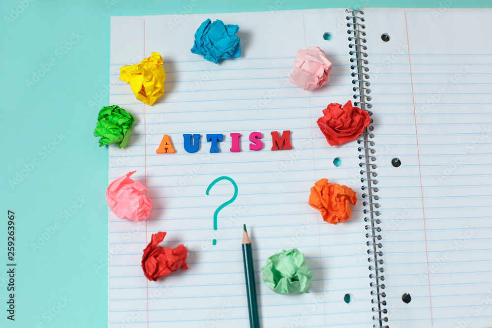 AUTISM colorful word from color wooden letters on notebook page and ...
