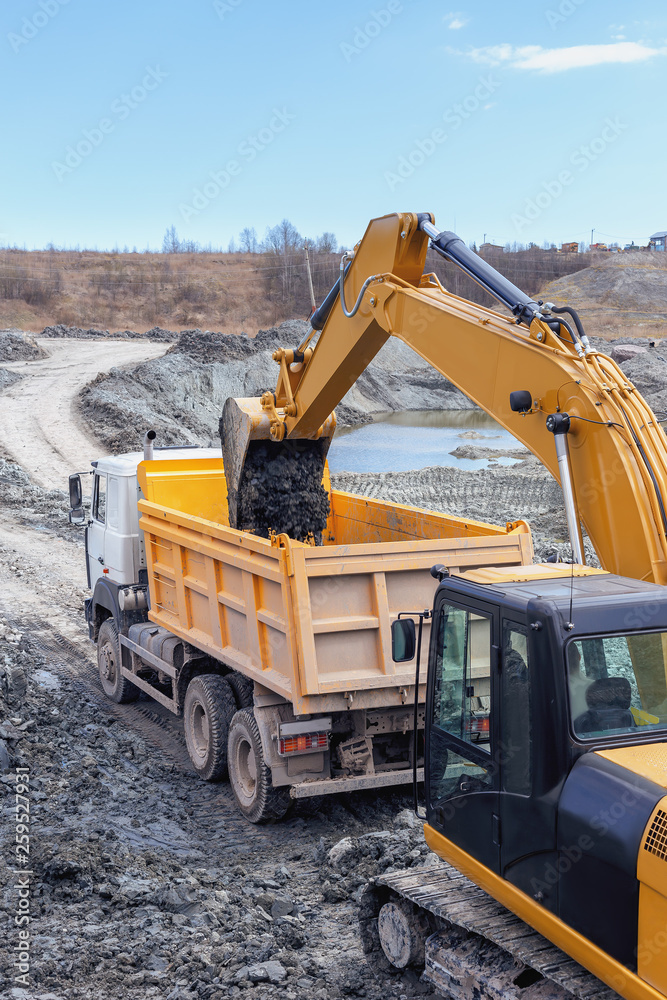 The process of loading the soil with an excavator bucket in a dump ...