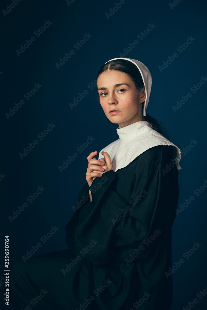 Hope and faith. Medieval young woman as a nun in vintage clothing and ...