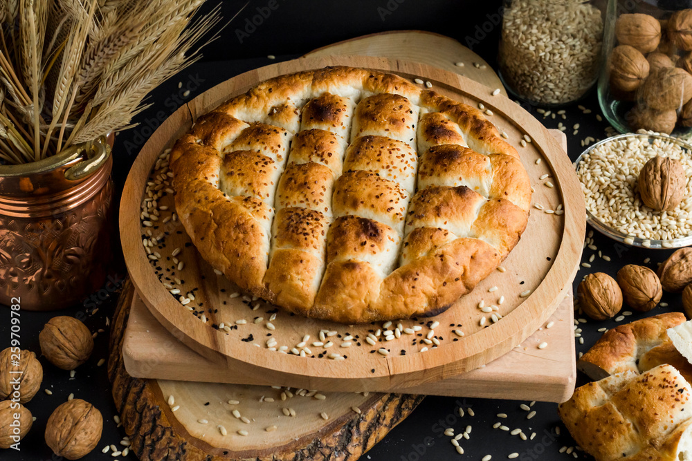 Ramadan bread is on the round wood plate with wheat grains,walnuts and ...