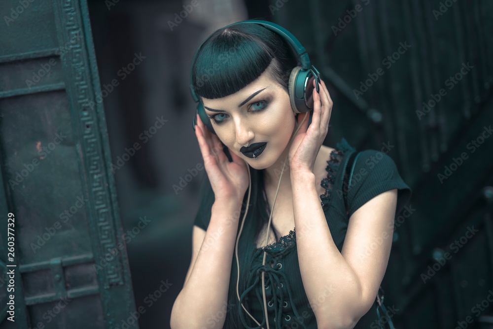 Urban goth girl listening to her favourite music over her big ...