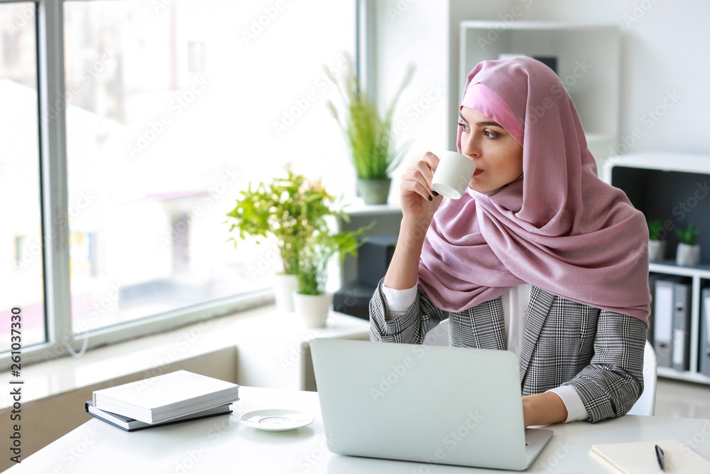 Muslim woman working on laptop in office Stock Photo | Adobe Stock