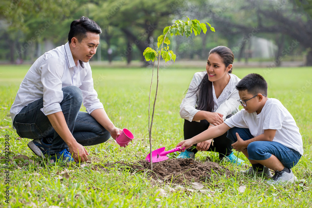 happy asian Family, parents and their children plant sapling tree ...