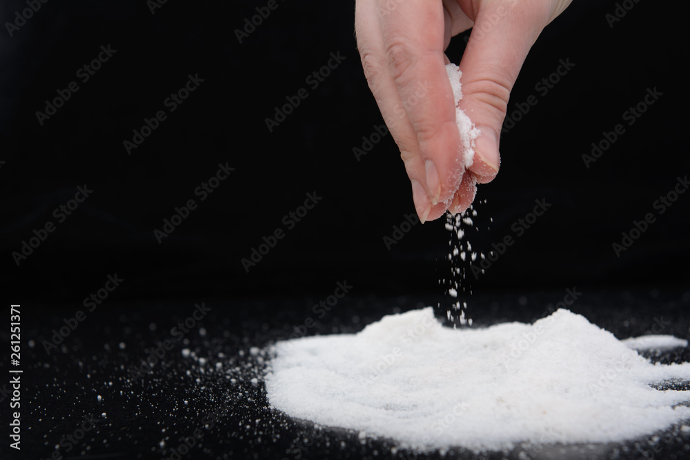 in the fingers of a young woman a pinch of salt, which she pours down ...