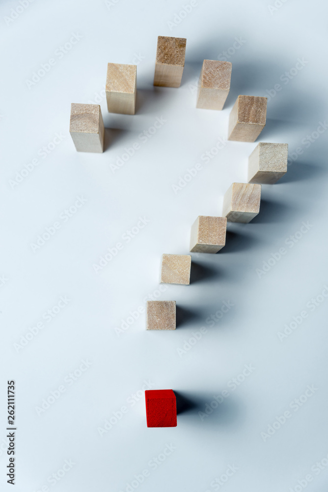 Question mark from wooden cubes on a uneven white background. Vertical ...
