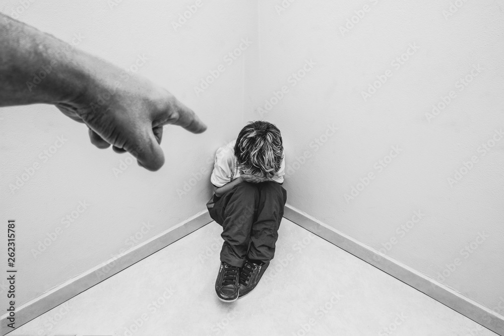 Foto de Stock Adult hand pointing at child in school uniform crying ...