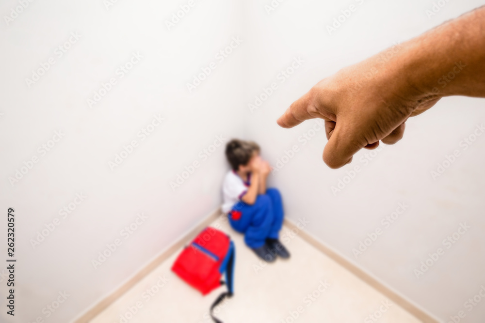 Adult hand pointing at child in school uniform crying, concept of child ...