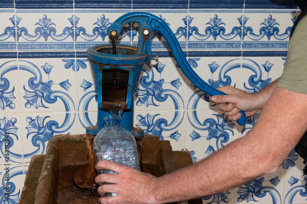 Llenando una botella de agua con una bomba de agua antigua Stock Photo ...