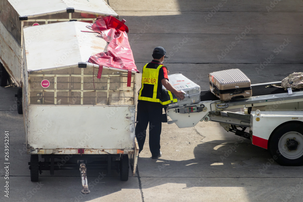 Foto de Stock asian man loader lifting up the luggage to conveyor belt ...