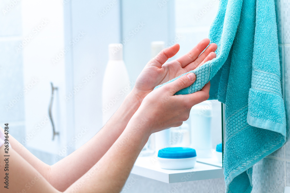 Woman wipe hands dry with towel after washing in bathroom at home ...