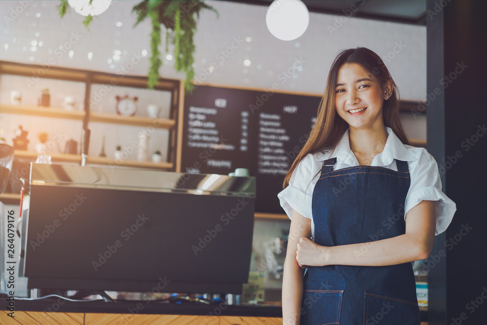 Pretty young asian waitress standing arms crossed in cafeteria.Coffee ...