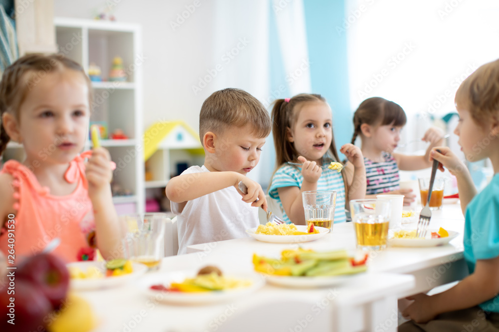 Group of preschool kids have a lunch in daycare. Children eating ...