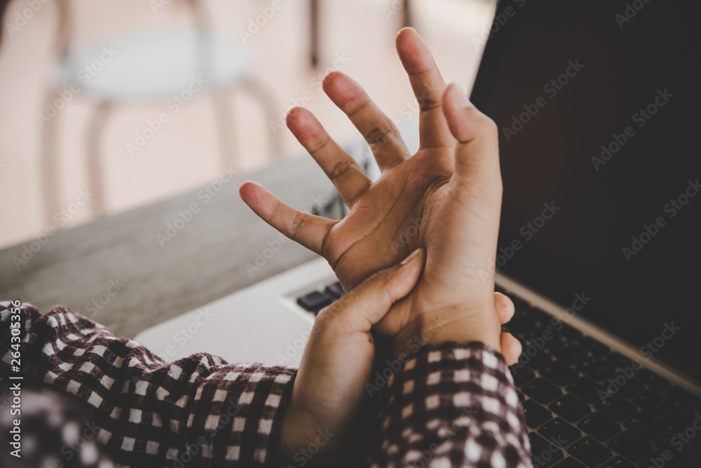 Business woman pressing the middle of her palm with her thumb to ...