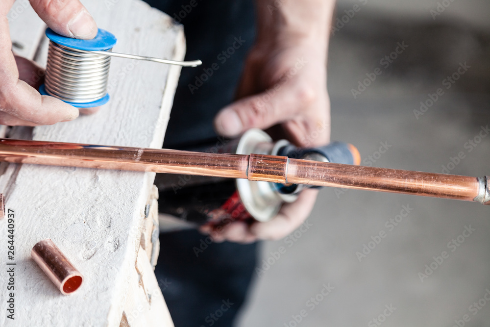 Closeup professional master plumber holding flux paste for soldering ...