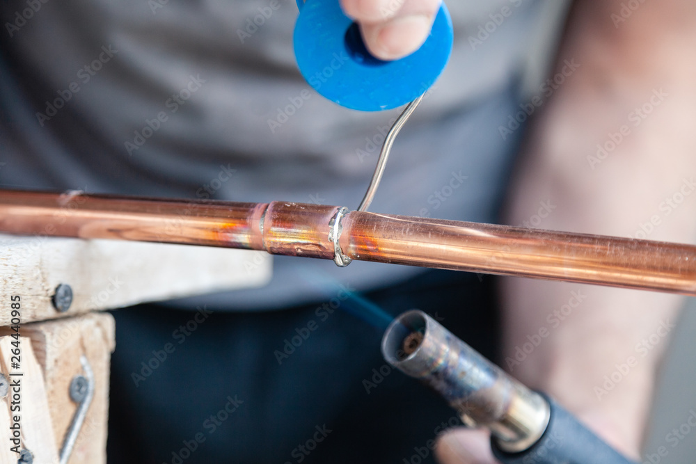 Closeup professional master plumber holding flux paste for soldering ...