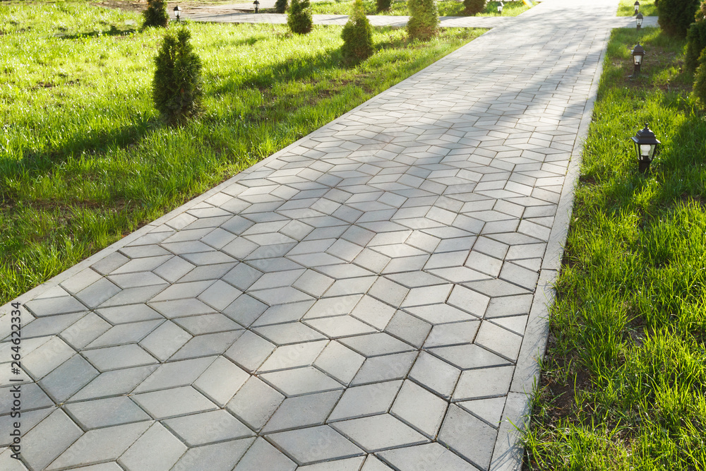 The footpath in the park is paved with diamond shaped concrete tiles ...
