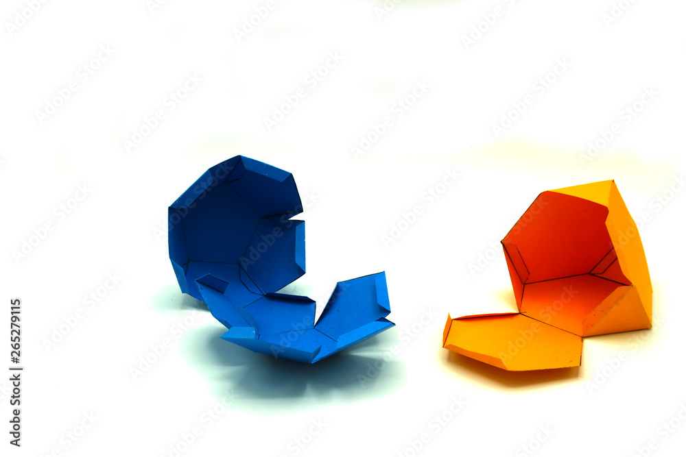 Geometric shape cut out of yellow and blue paper and photographed on ...