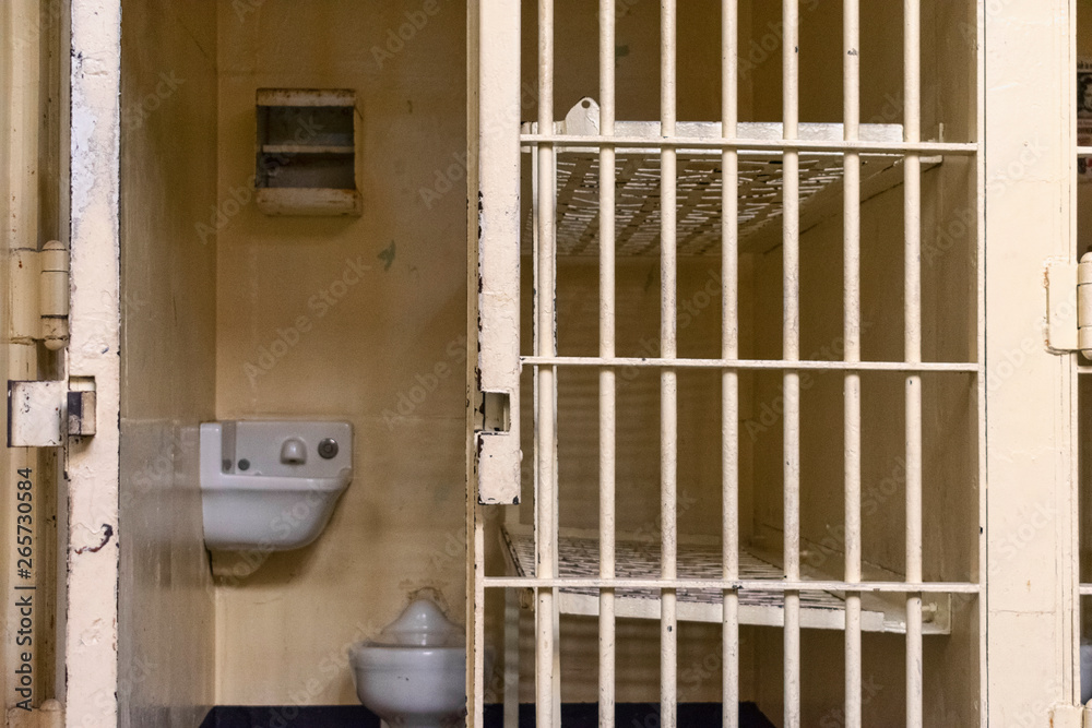Open prison cell with metal bed, porcelain sink and toilet for two law ...