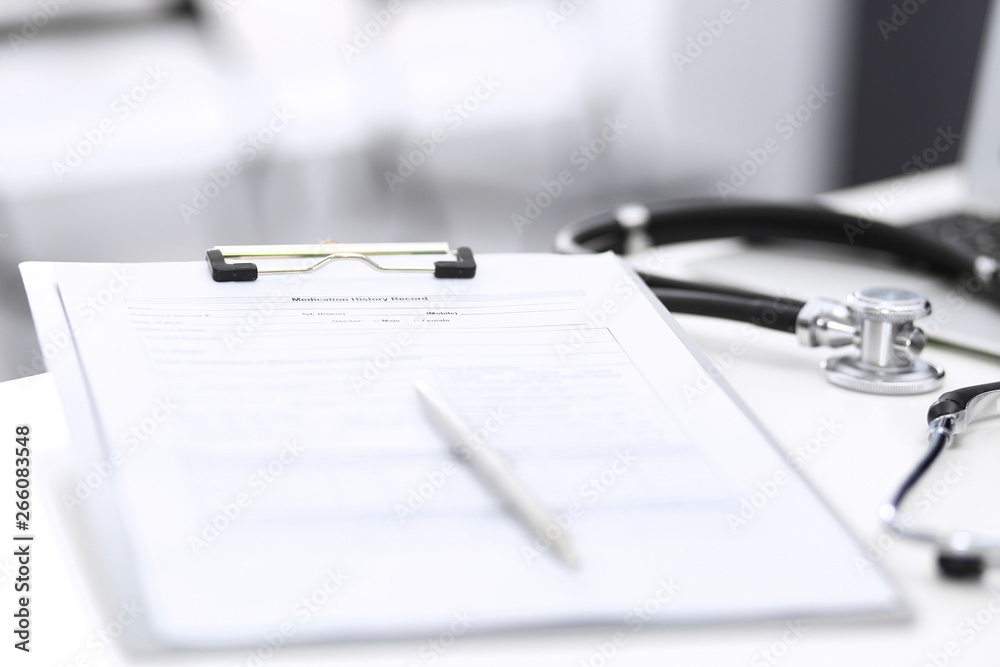 Stethoscope, clipboard with medical form lying on hospital reception ...